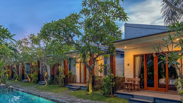 Uma casa moderna com piscina, móveis de exterior e vegetação exuberante.