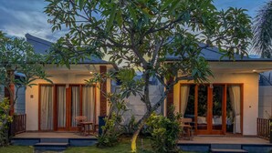 Uma casa moderna com piscina, portas de madeira e um jardim bem cuidado.