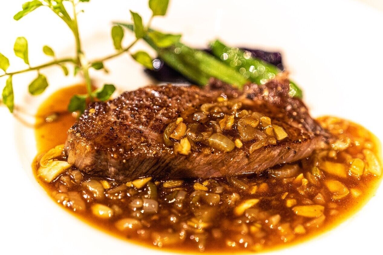 Bife com molho e legumes em um prato.