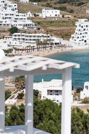 Uma vila costeira com edifícios brancos, uma praia e vista clara para o mar.