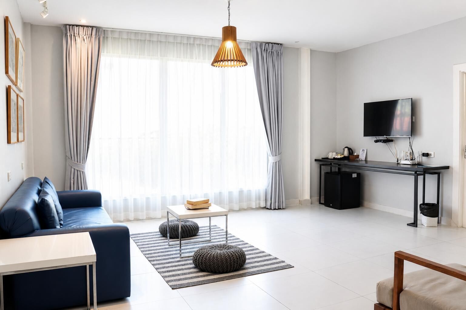 Uma sala de estar moderna com um sofá, uma mesa de centro, uma televisão e uma escrivaninha.