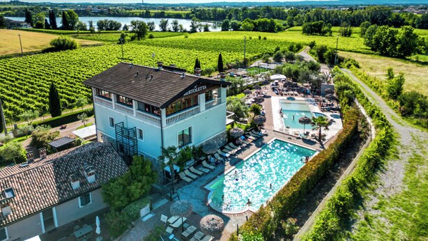 Um hotel com piscina, área de estar externa e vista para a paisagem ao redor.