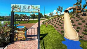 Um parquinho com escorrega, balanços e uma placa com a inscrição 'Bertoland Your Family Park'.