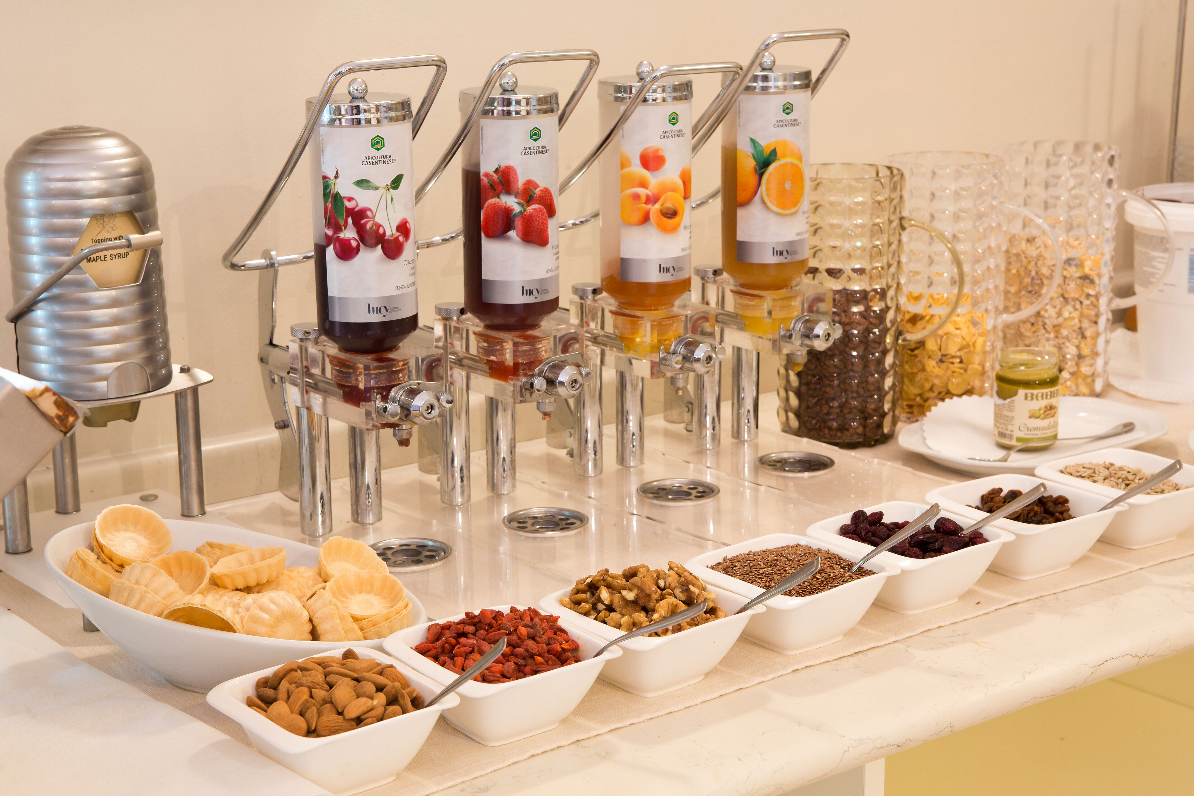 Disposição de buffet com diversos alimentos e dispensadores de bebidas.