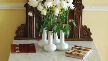 Um armário de madeira com bancada de mármore, contendo um vaso com flores e um livro.