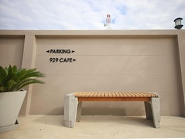 Parede com placas de sinalização para 'PARKING' e '929 CAFE'.