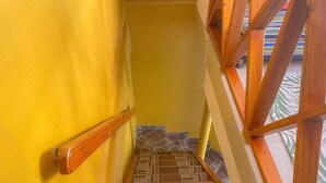 Escadaria com corrimão de madeira e ladrilhos decorativos.