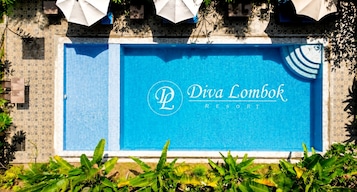 Uma piscina com um logotipo e o nome 'Diva Lombok Resort' na lateral.