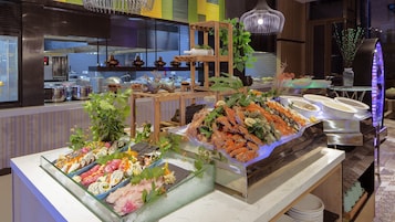 Buffet variado com opções de frutos do mar, incluindo camarão e sushi, exposto sobre gelo.