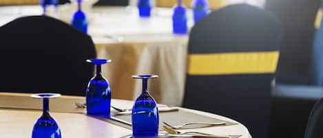 Uma mesa de jantar com copos de vidro azuis e uma cadeira amarela.