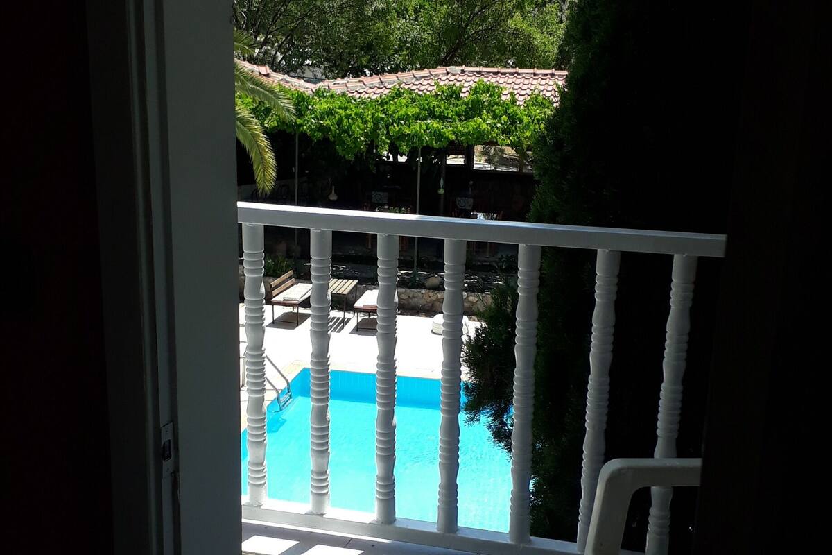 Varanda com piscina, grade branca e cadeira branca.