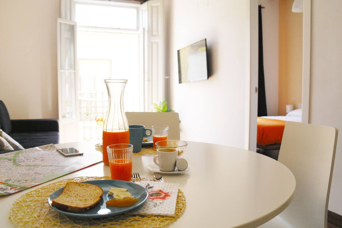 Uma mesa de café da manhã com um mapa, um copo de suco de laranja, um prato com torradas e uma xícara de café.