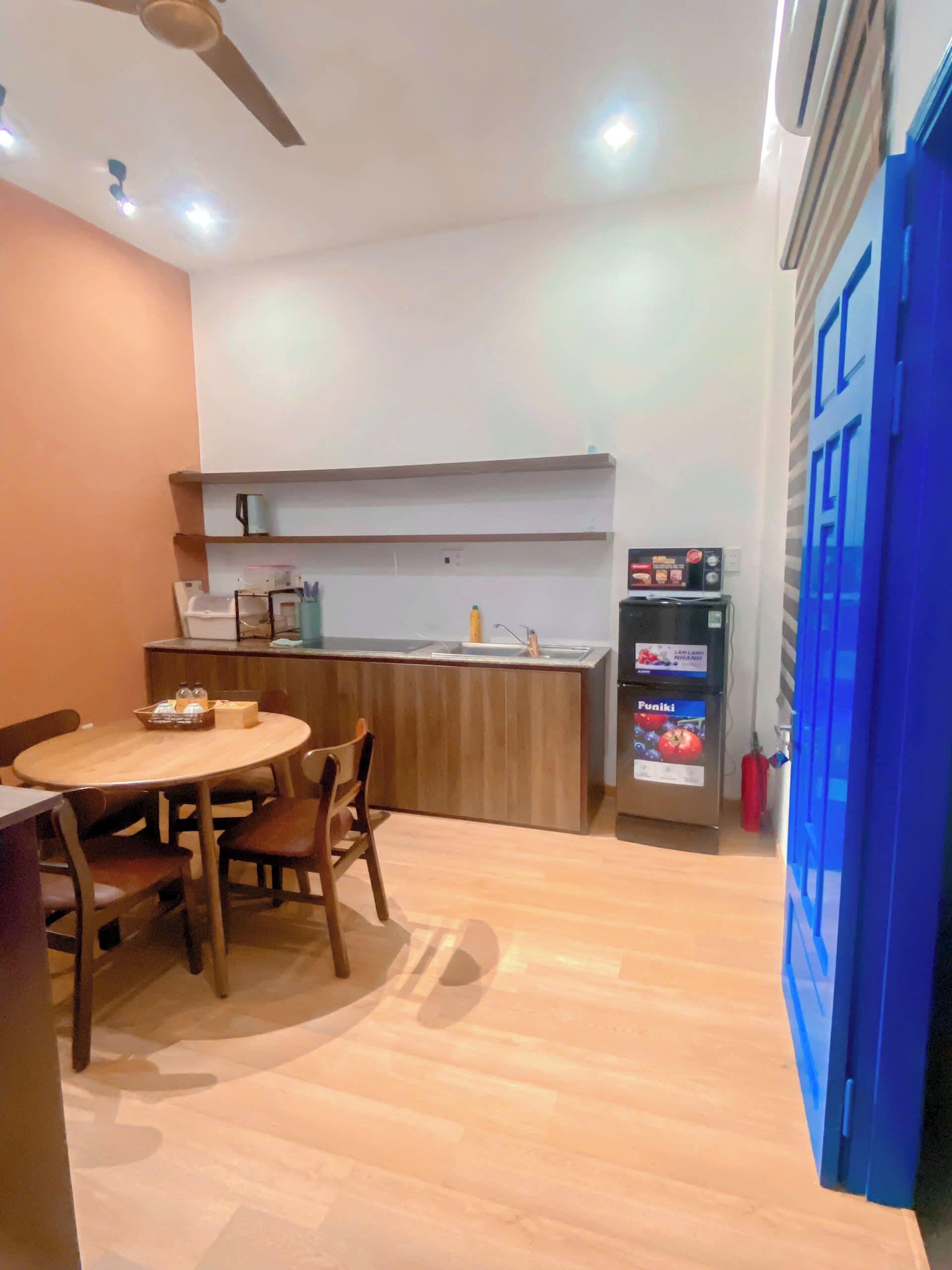 Cozinha compacta com área de refeições, forno embutido e geladeira.