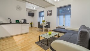 Uma sala de estar moderna com um sofá, uma mesa de centro e um espaço de jantar com uma mesa e cadeiras.