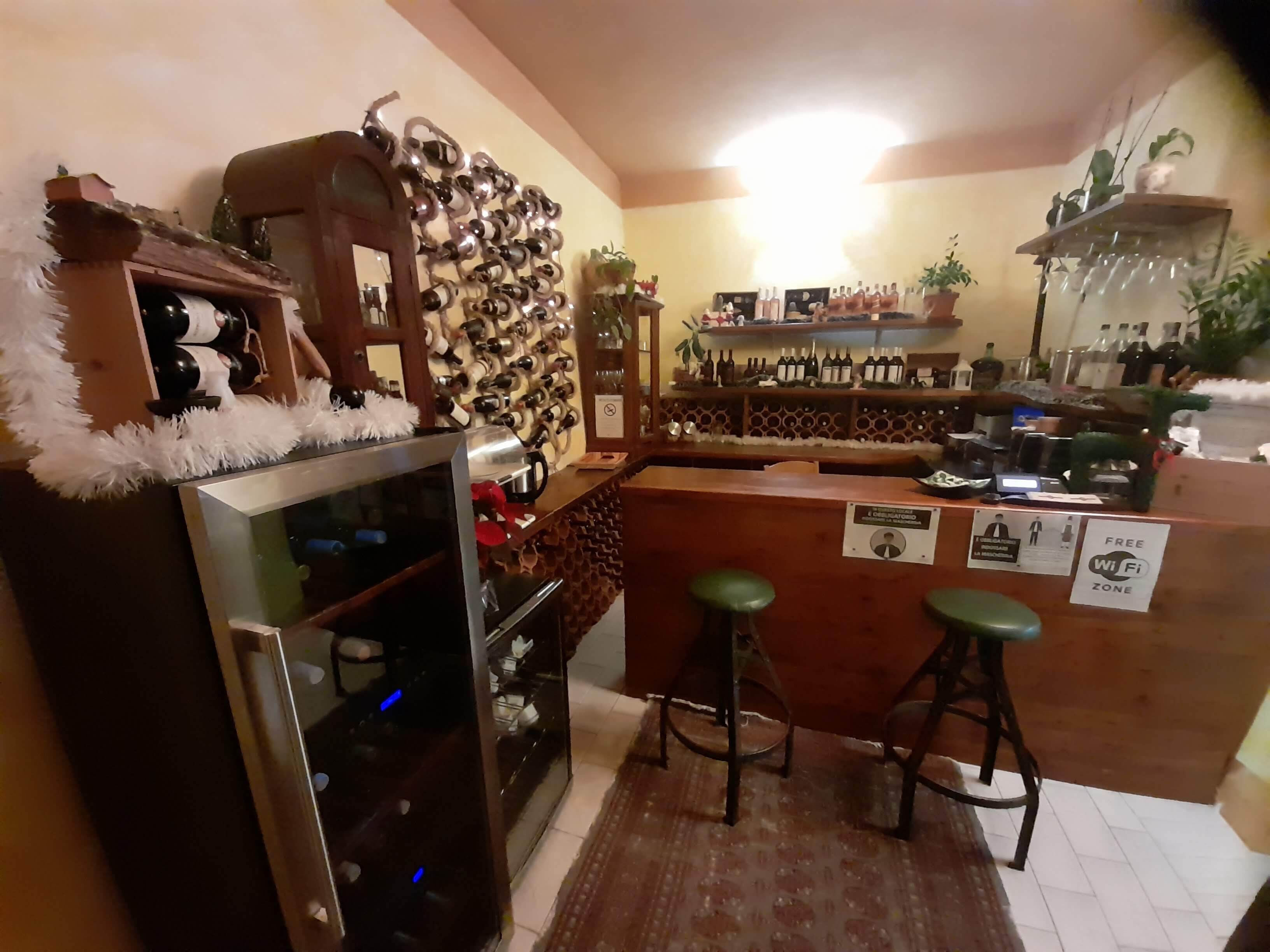 Área de bar com adega, banquetas e balcão com sinalização de zona com WiFi gratuito.