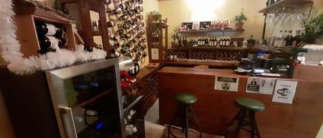 Área de bar com adega, banquetas e balcão com sinalização de zona com WiFi gratuito.