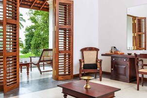 Um quarto com uma mesa de madeira, duas cadeiras, um armário e um espelho grande.