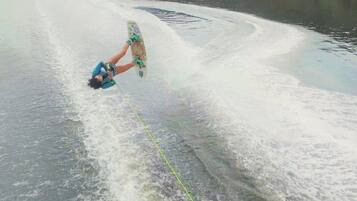 Um praticante de wakeboard executando uma manobra em um lago.