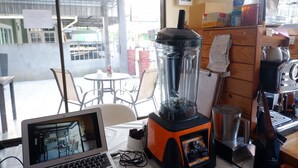 Cozinha equipada com liquidificador, um laptop e diversos eletrodomésticos.