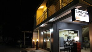 Um edifício de dois andares com uma placa que diz "Bangtao Corner".