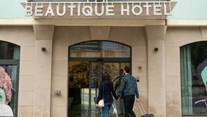 Entrada de um hotel boutique com uma placa que diz 'WC BEAUTIQUE HOTEL'.