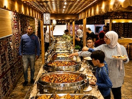 Buffet com diversos pratos e parede estampada.