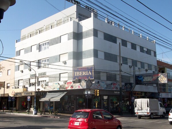 Um hotel com vários andares e um grande letreiro 'IBERIA', com fachada moderna, janelas amplas e varandas.
