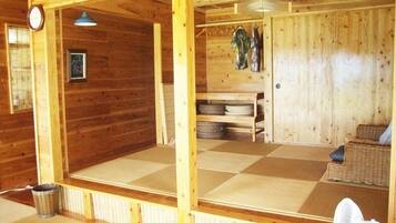 Um interior de madeira com piso xadrez, um ventilador e um relógio.
