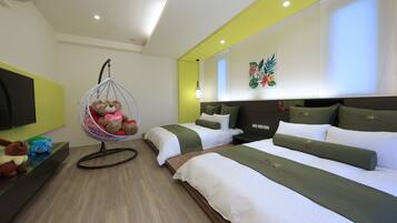 Quarto de hotel com duas camas, uma cadeira suspensa com brinquedos de pelúcia, uma televisão de tela plana e uma parede com arte tropical.