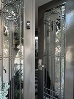 Um portão de metal com desenhos elaborados e um cadeado eletrônico.
