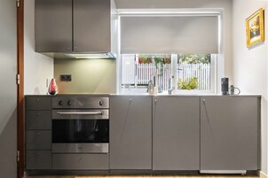 Cozy Apartment Ground Floor | Cozinha privada | Geladeira grande, micro-ondas, fogão, cooktop