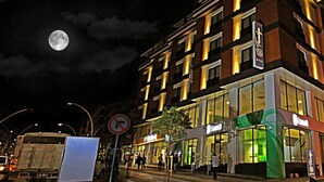 Um hotel com fachada moderna, janelas amplas e uma placa chamativa.