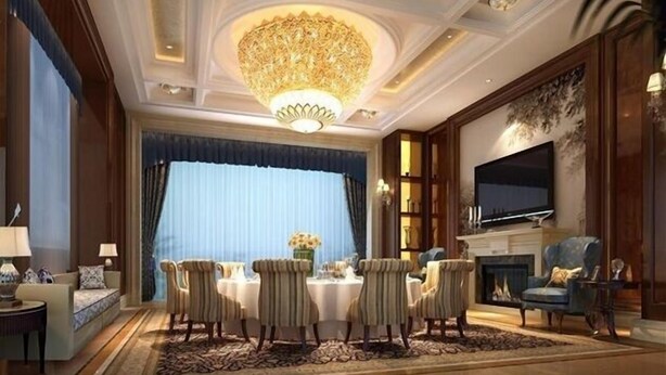 Uma sala de estar luxuosa com um candelabro, lareira, televisão e um espaço de estar com mesa e cadeiras.