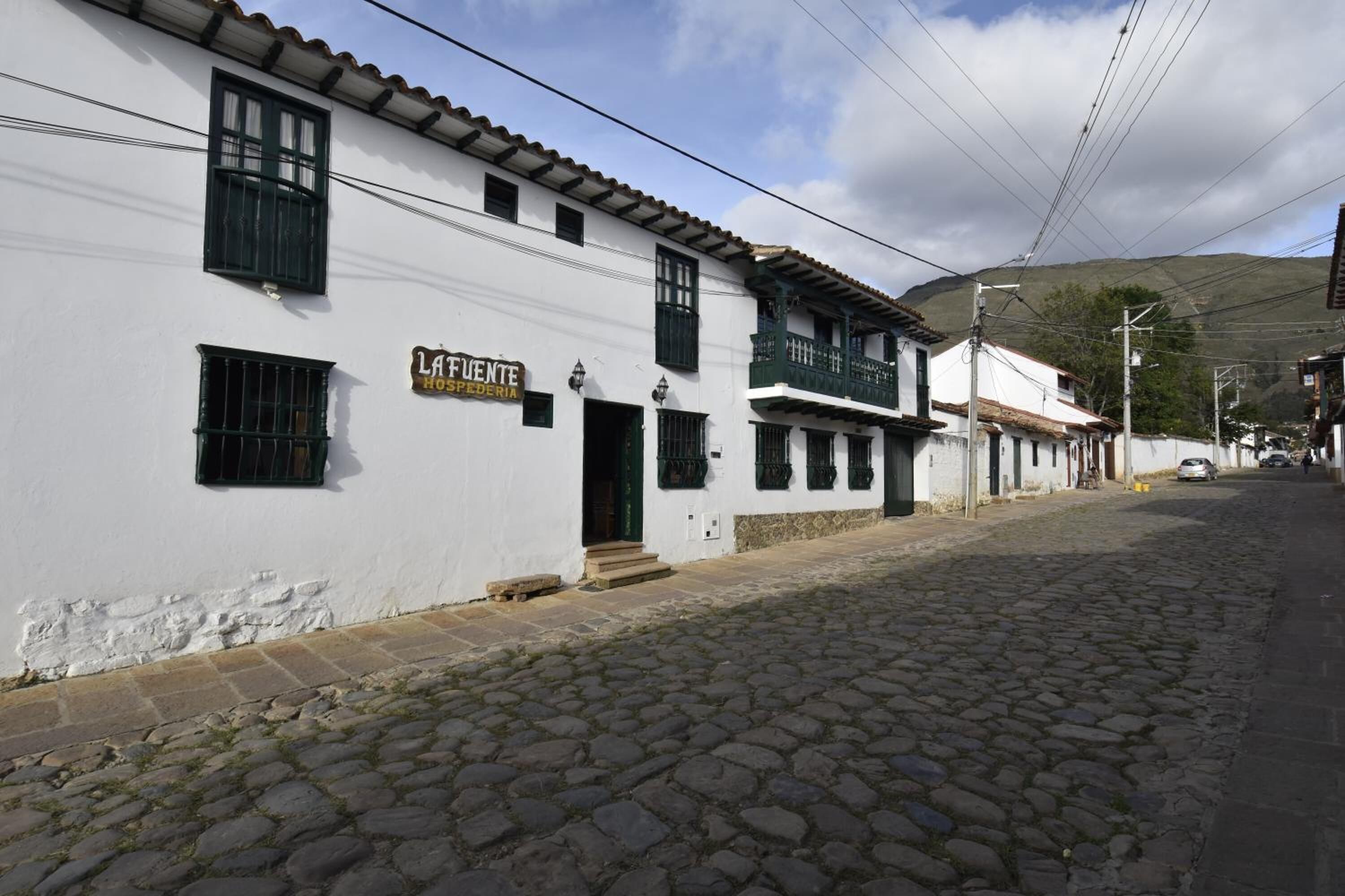 Um edifício branco com uma placa indicando 