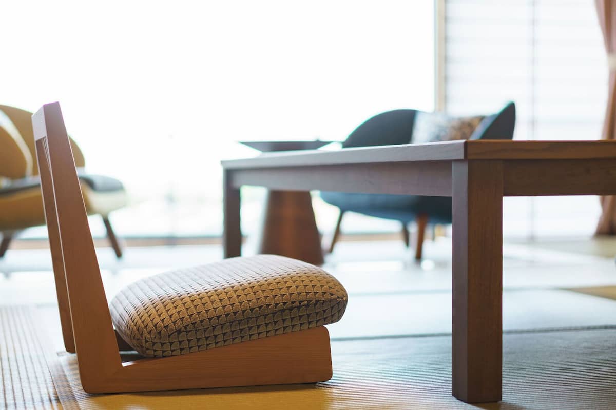 Uma sala de estar moderna com uma cadeira de madeira e um sofá.