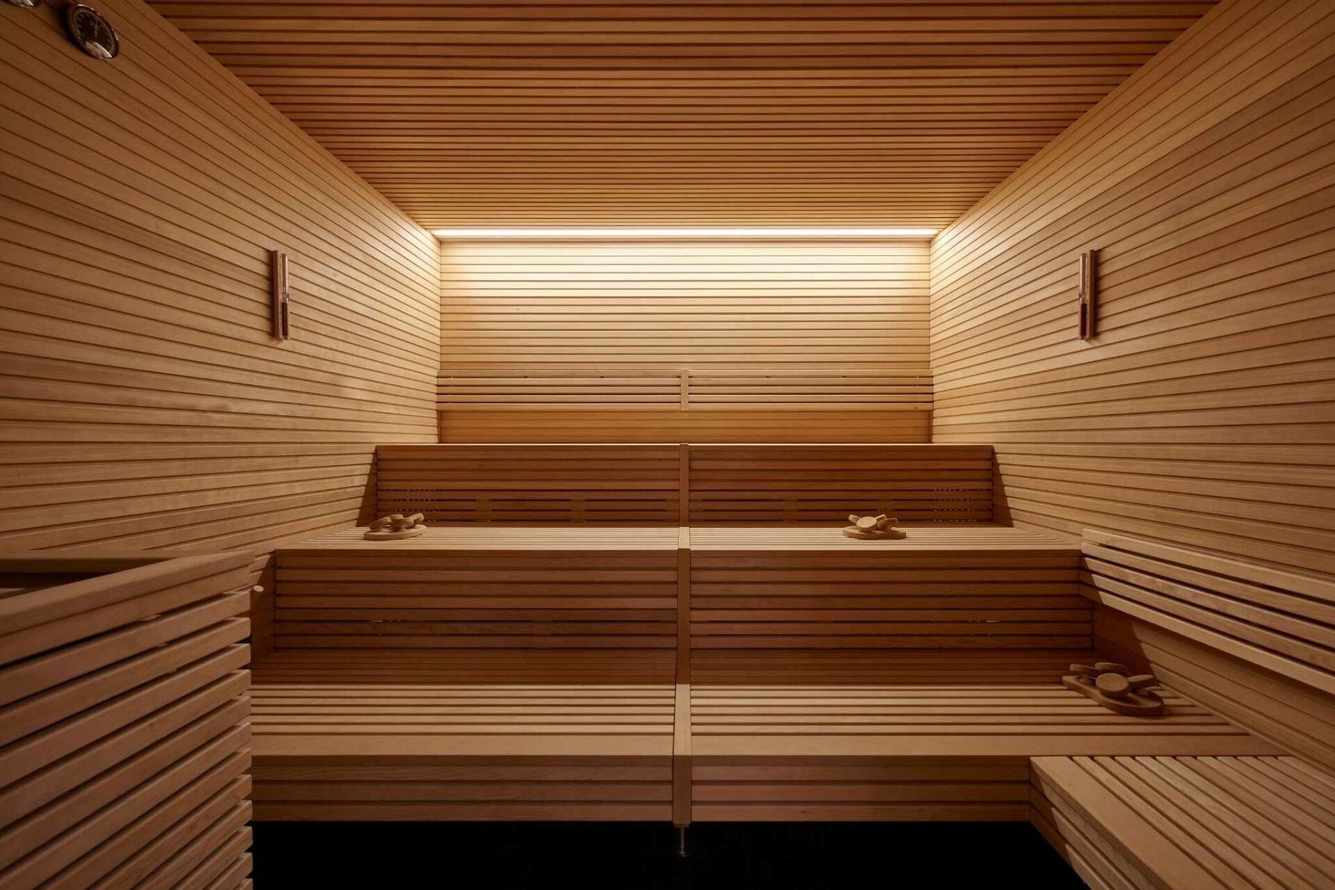 Uma sauna com ripas de madeira nas paredes e bancos.