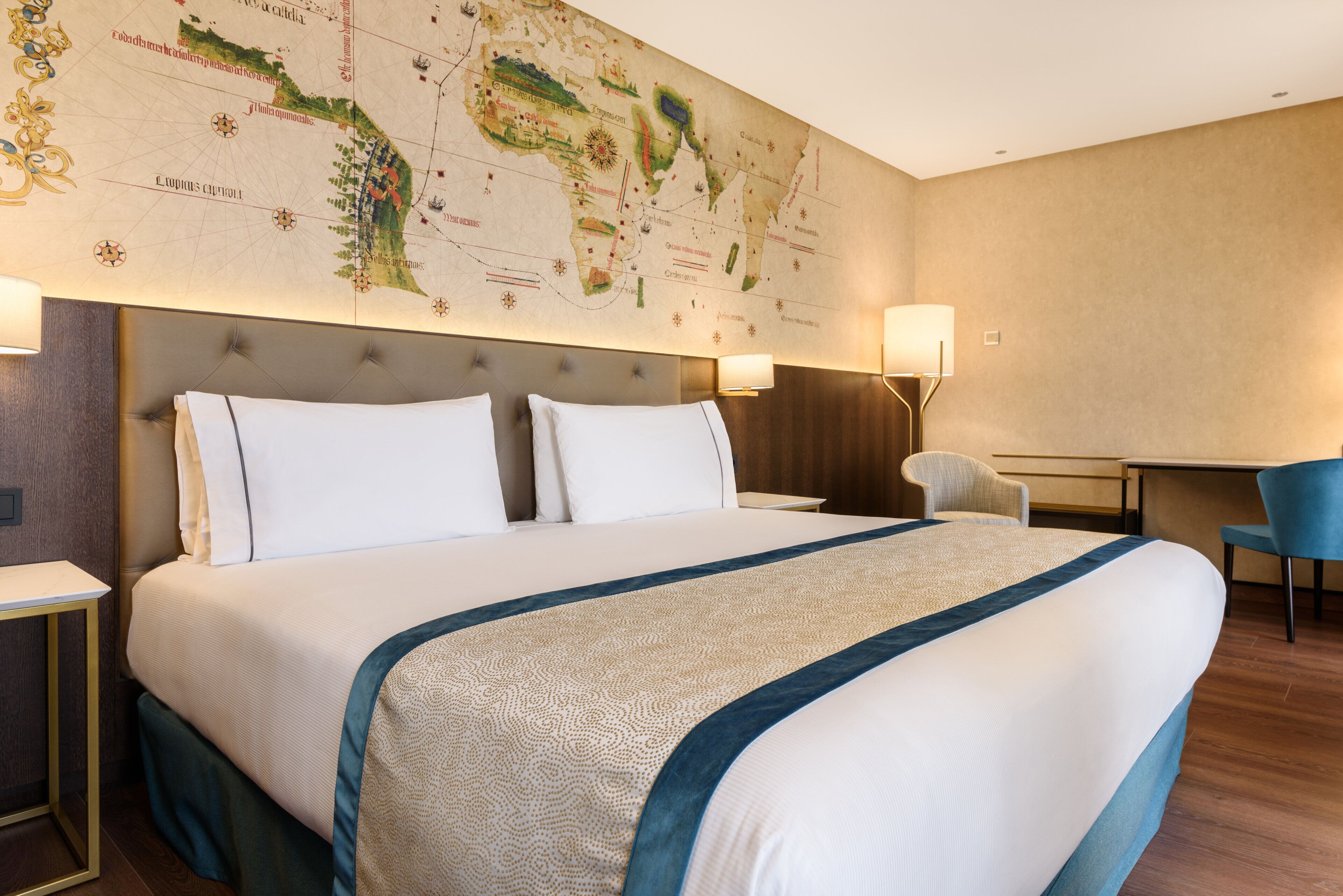 Quarto de hotel com uma cama grande, uma escrivaninha e uma cadeira.