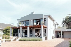 Um edifício moderno de dois andares com área de estar coberta e garagem.