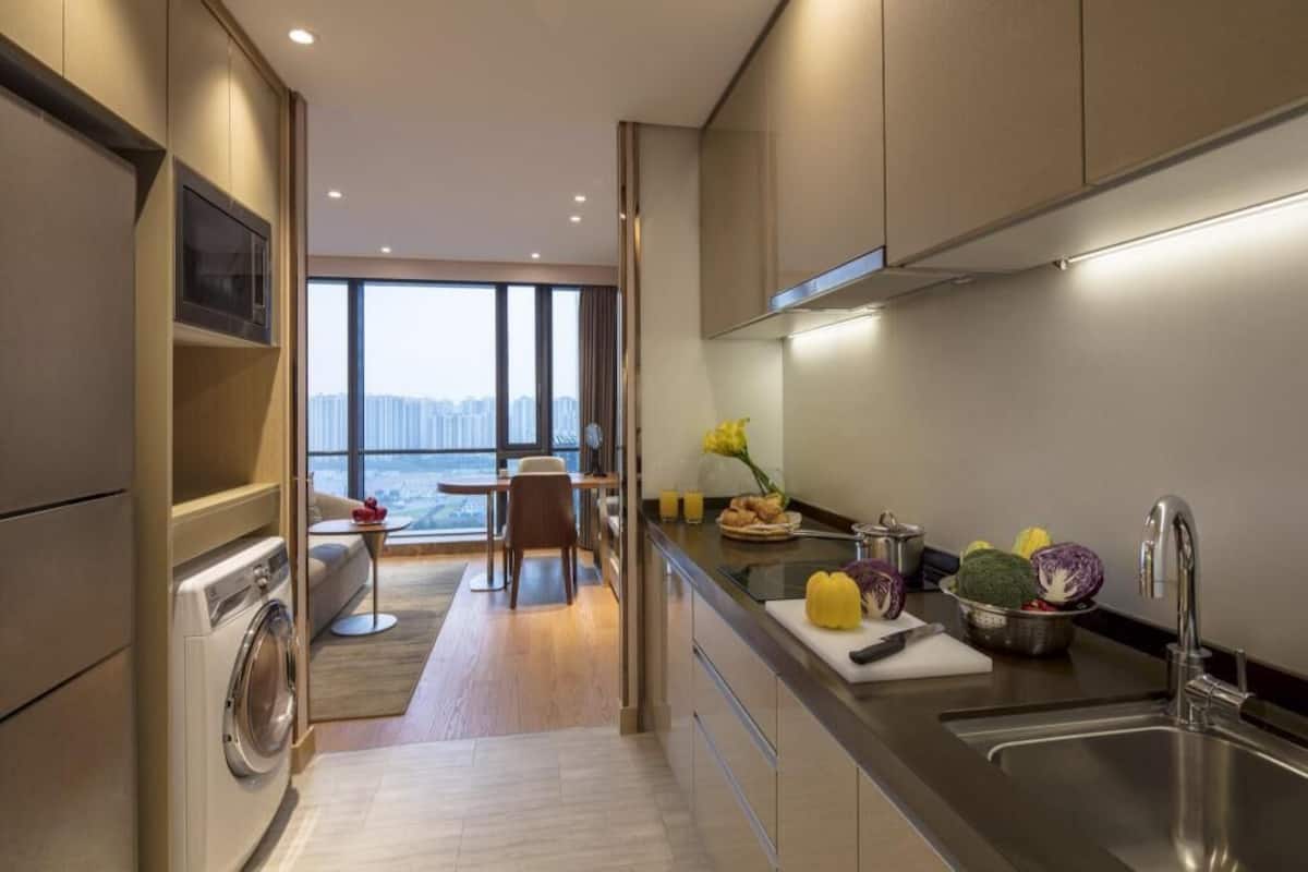 Uma cozinha moderna com máquina de lavar embutida, área de refeições com vista e uma janela grande.