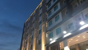 Um edifício de vários andares com design arquitetônico moderno, apresentando uma série de colunas verticais e varandas.