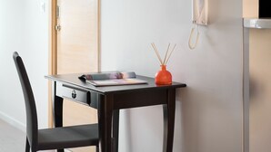 Uma pequena área de refeições com mesa, cadeira e um quadro na parede.