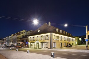 Um hotel chamado "Du Chateau", com arquitetura europeia clássica, destacando uma entrada imponente e diversas janelas.