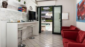 Cozinha moderna com área de bar, um sofá vermelho e vista para o exterior.