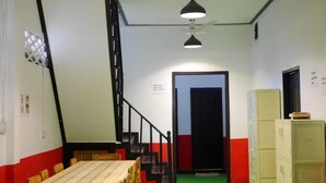 Quarto com escada, mesa com cadeiras, ventilador de teto e armários.