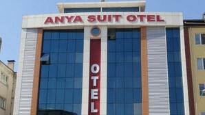 Um edifício com uma placa que diz "ANYA SUIT OTEL" e uma placa vertical com a palavra "OTEL".
