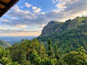 Paisagem montanhosa com vegetação exuberante e céu claro.