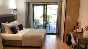 Quarto de hotel com uma cama, uma escrivaninha, uma cadeira, uma mesinha de centro e um tapete de couro.