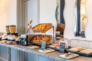 Um balcão de buffet com diversos alimentos, incluindo pão, fiambre e queijo.