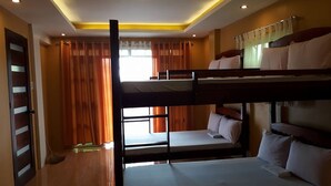 Quarto com beliche, janela, cortinas e luminária no teto.