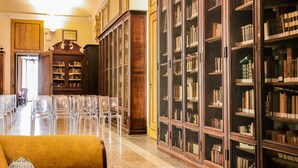 Uma biblioteca com fileiras de cadeiras e estantes de livros.